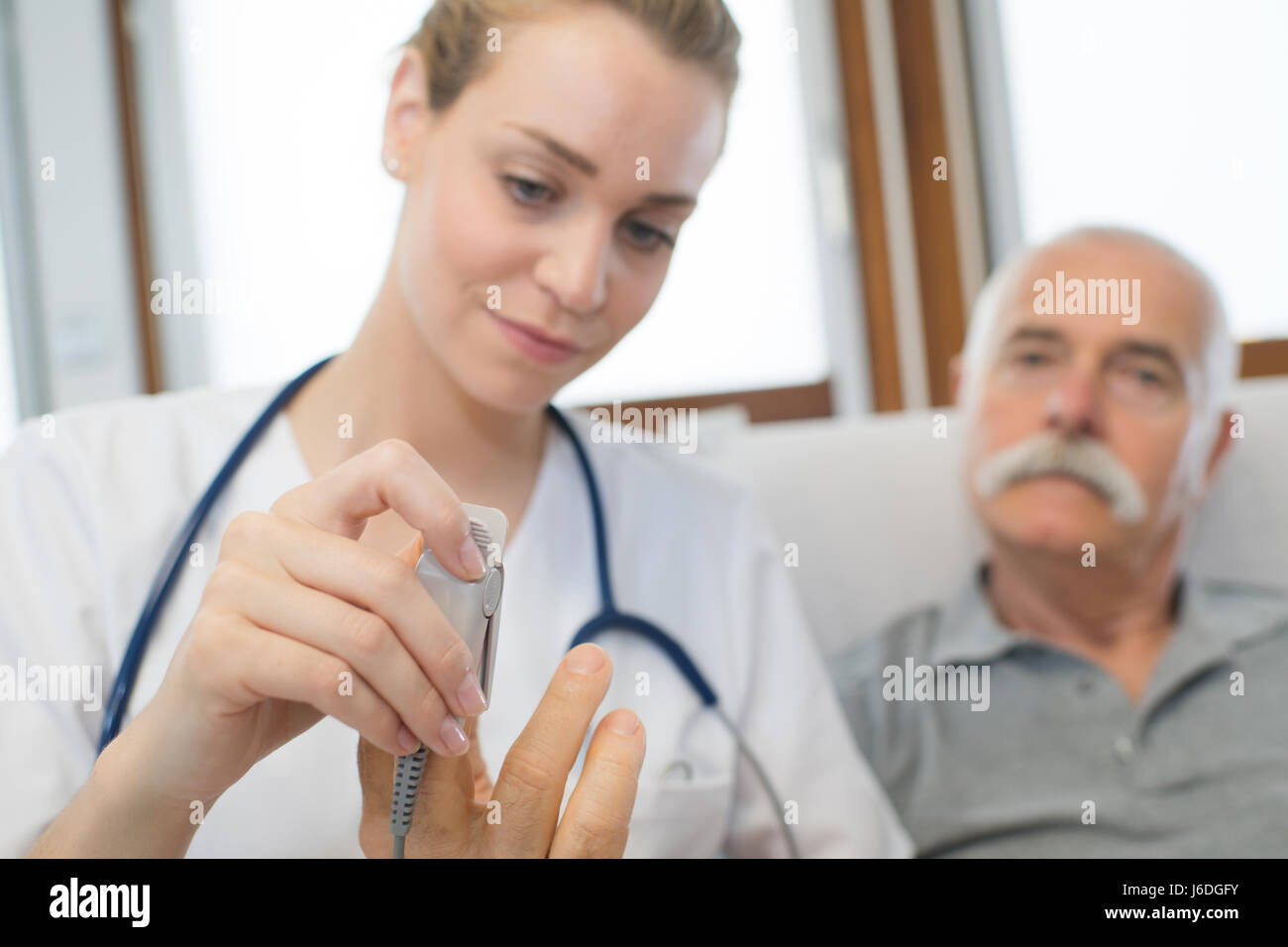 Doctor putting pulse reader on patient's finger Stock Photo - Alamy
