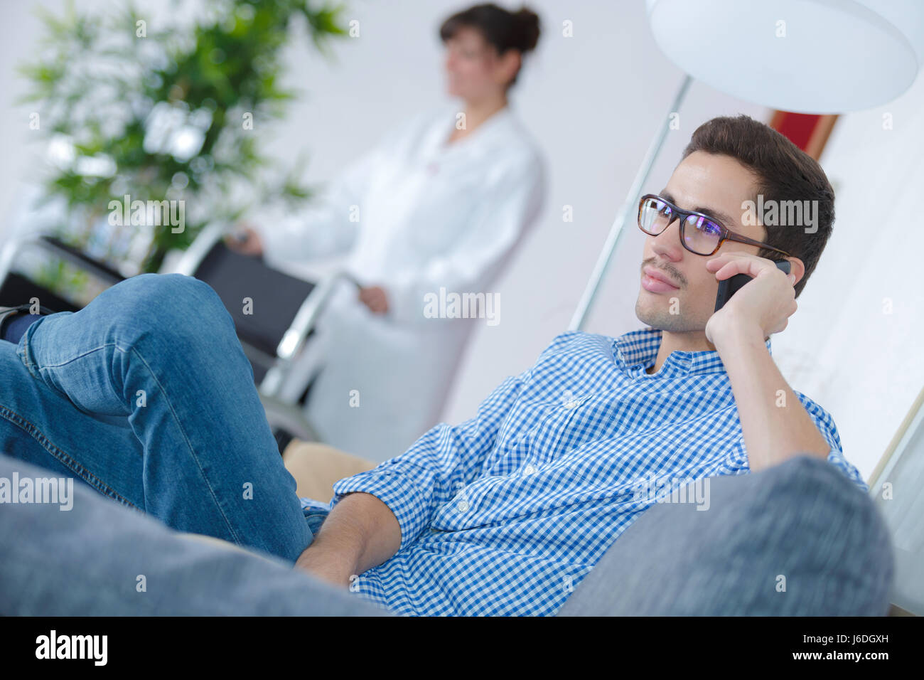 Man in waiting room using mobile phone Stock Photo - Alamy