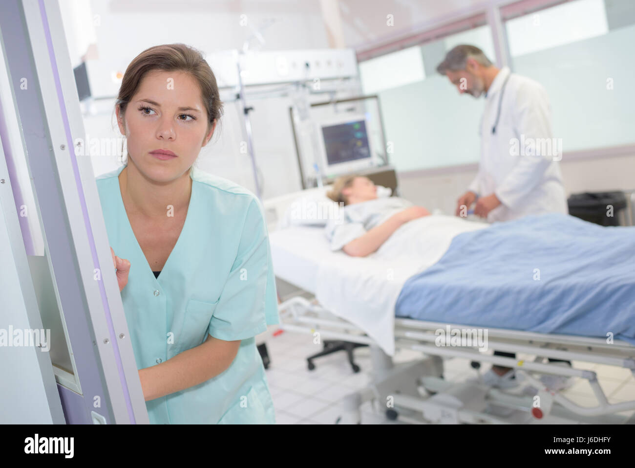 worried nurse looking away and thinking about something Stock Photo - Alamy