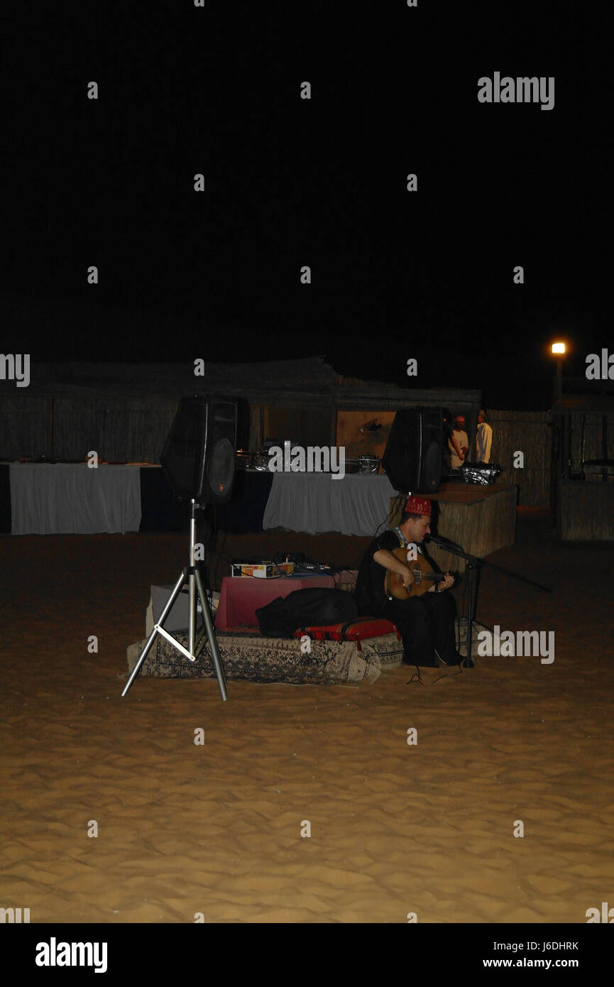 Night flashlight portrait Arab man in black traditional clothes playing ...