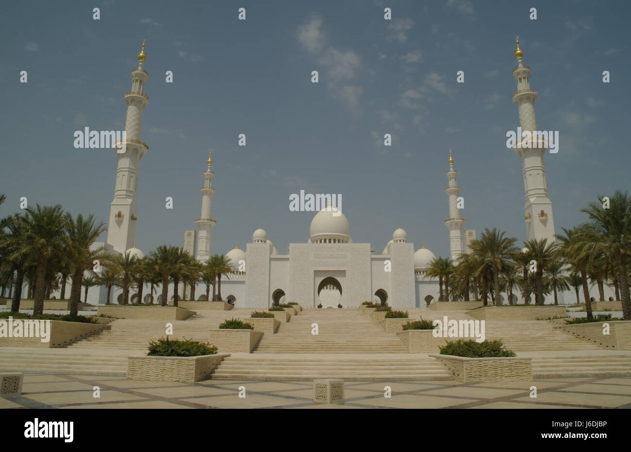 Blue sky view stairway with flanking palm trees rising to minarets and ...