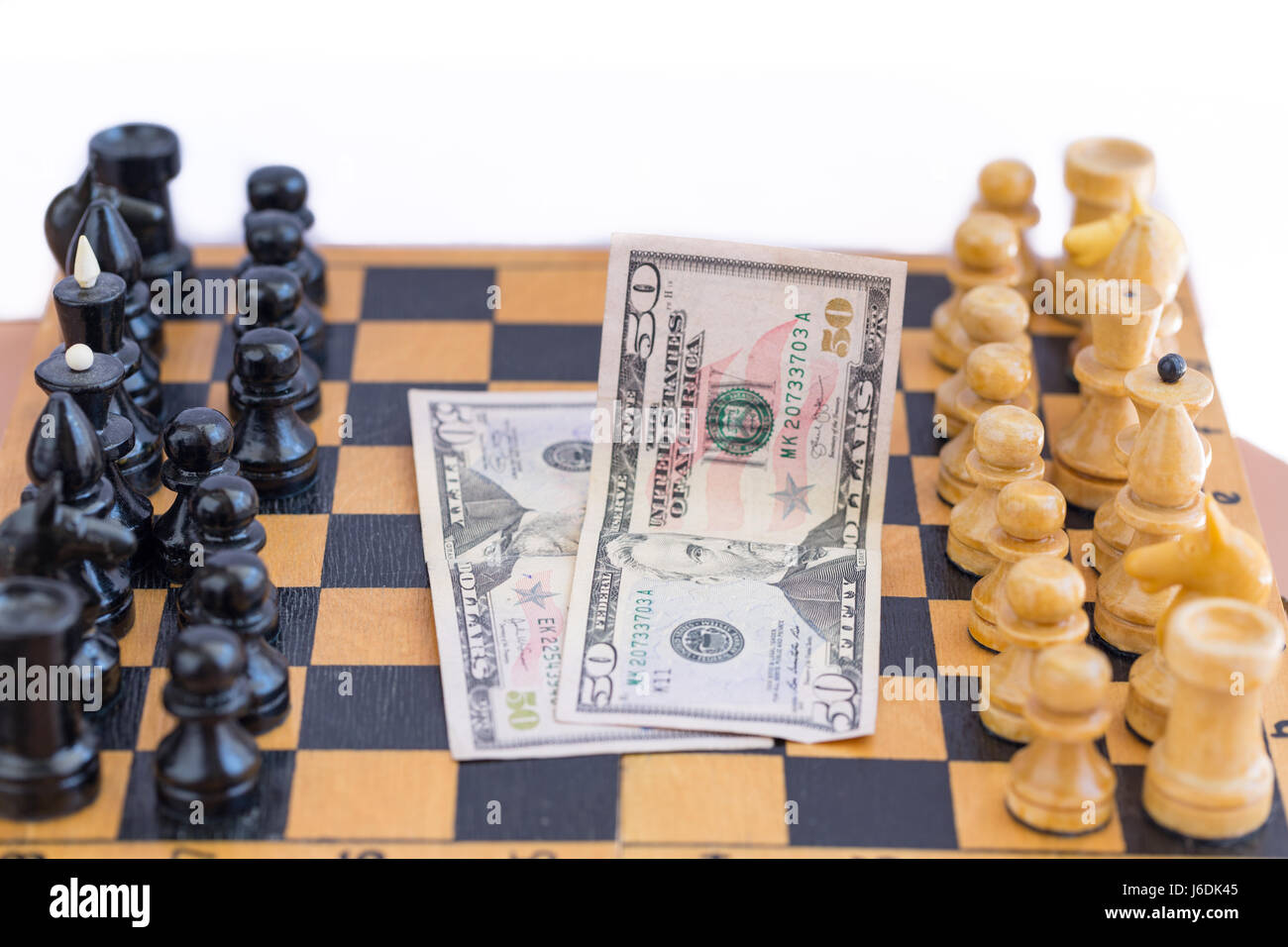 Chess components and money between them Stock Photo - Alamy