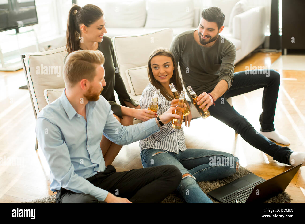Group of male and female friends having fun in room at home Stock Photo ...