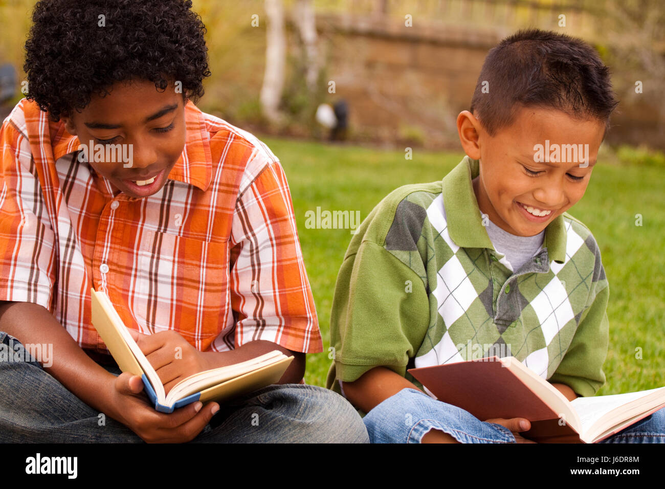 Happy young kids smiling and reading Stock Photo - Alamy