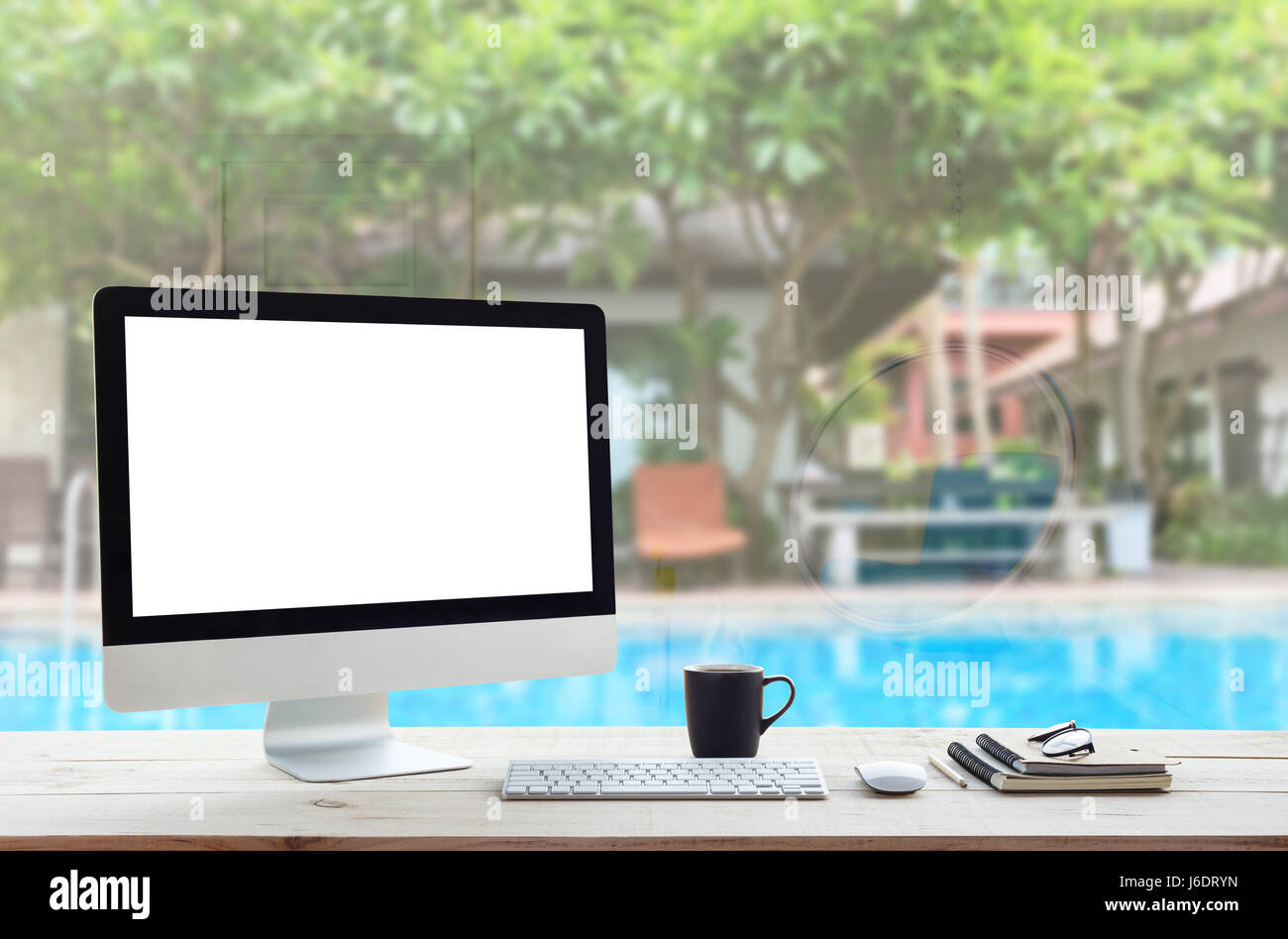 desktop computer on work table and see through resort hotel background ...