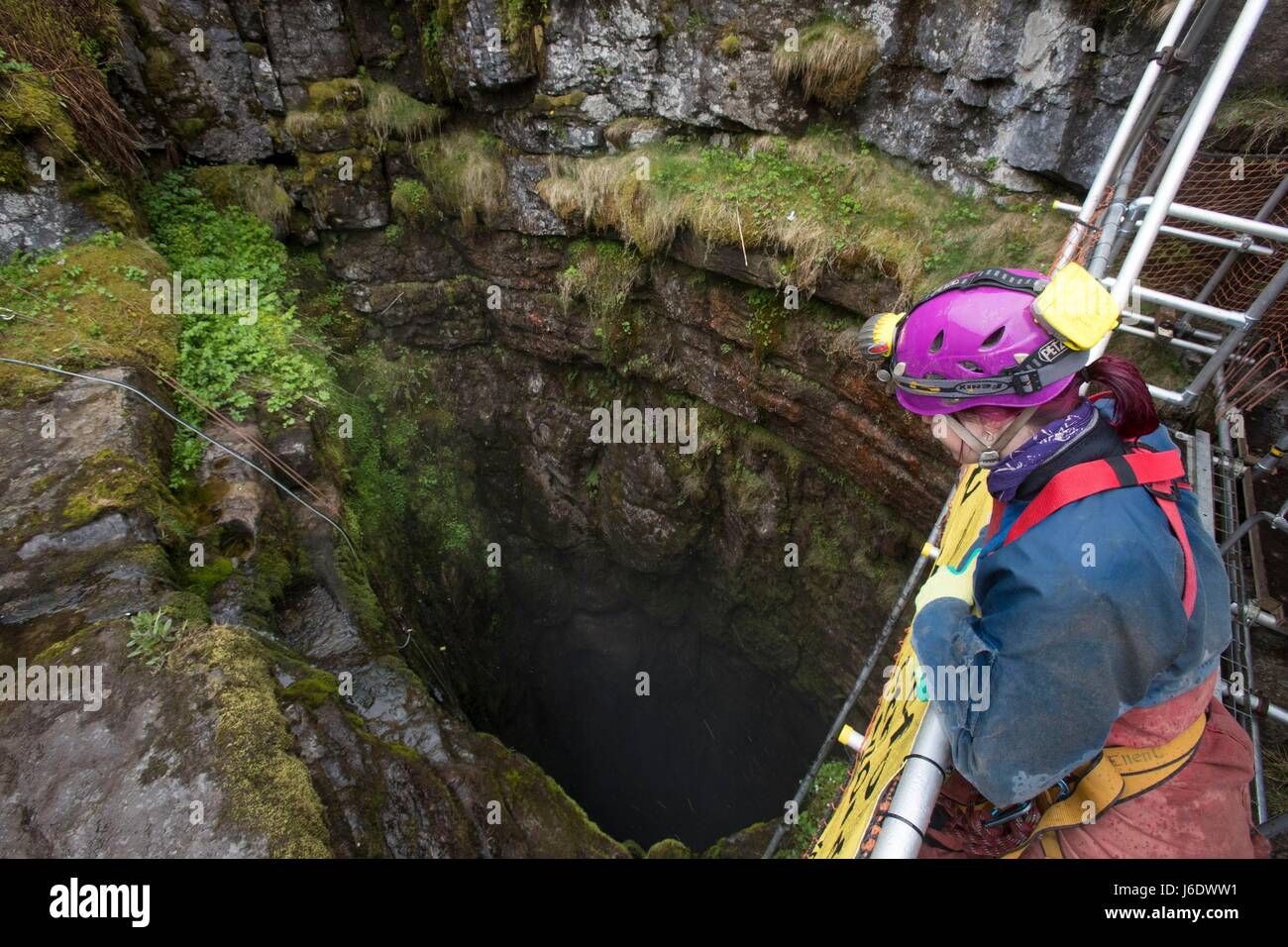 A potholer looks at the entrance to Gaping Gill, the largest cavern in ...