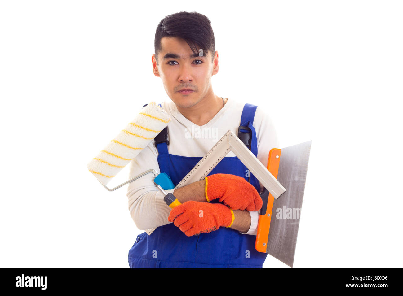 Man in overall with gloves holding spatula, roll, ruler and screwdriver ...