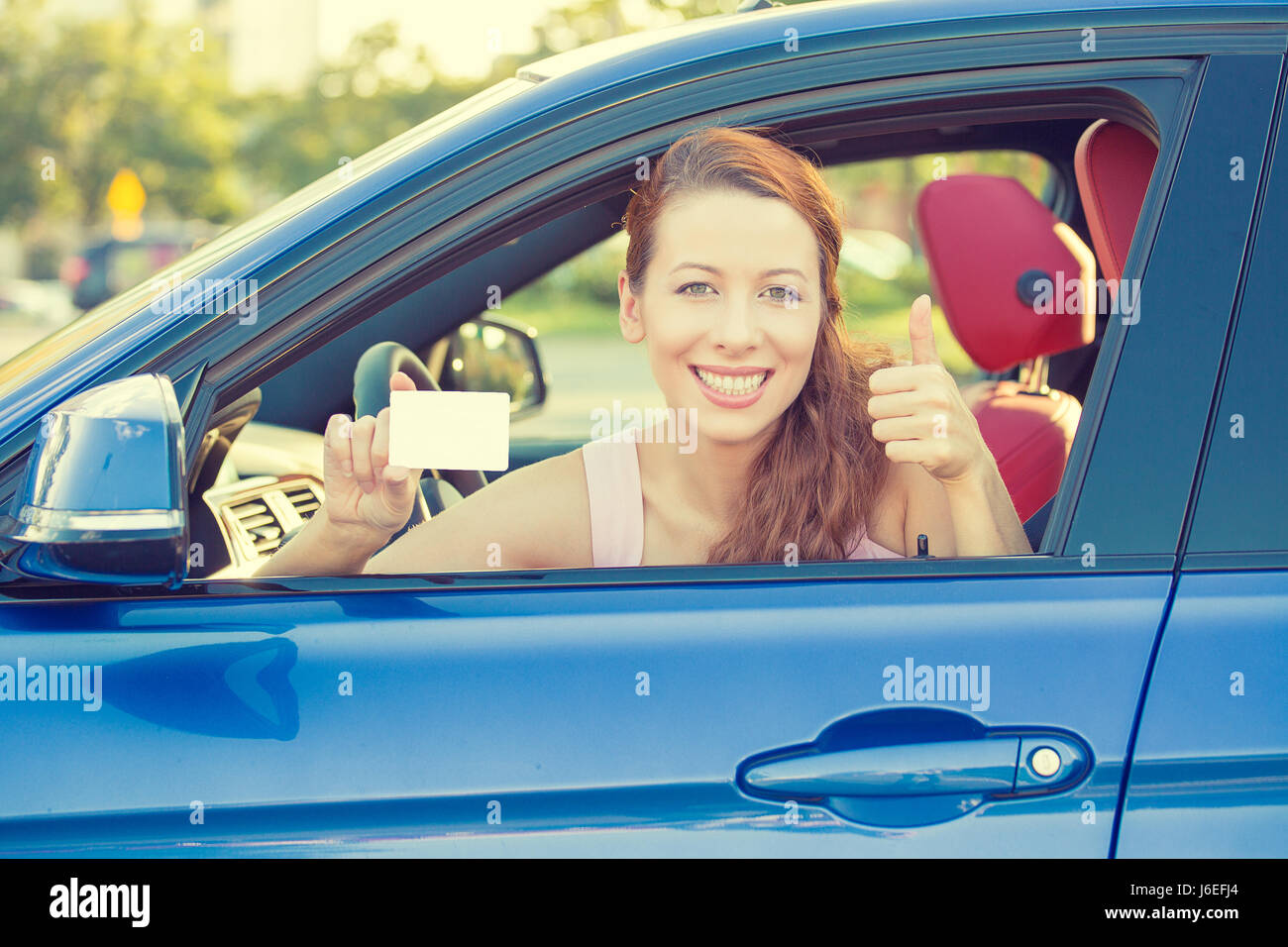 Car. Woman driver happy smiling showing thumbs up coming out of car ...