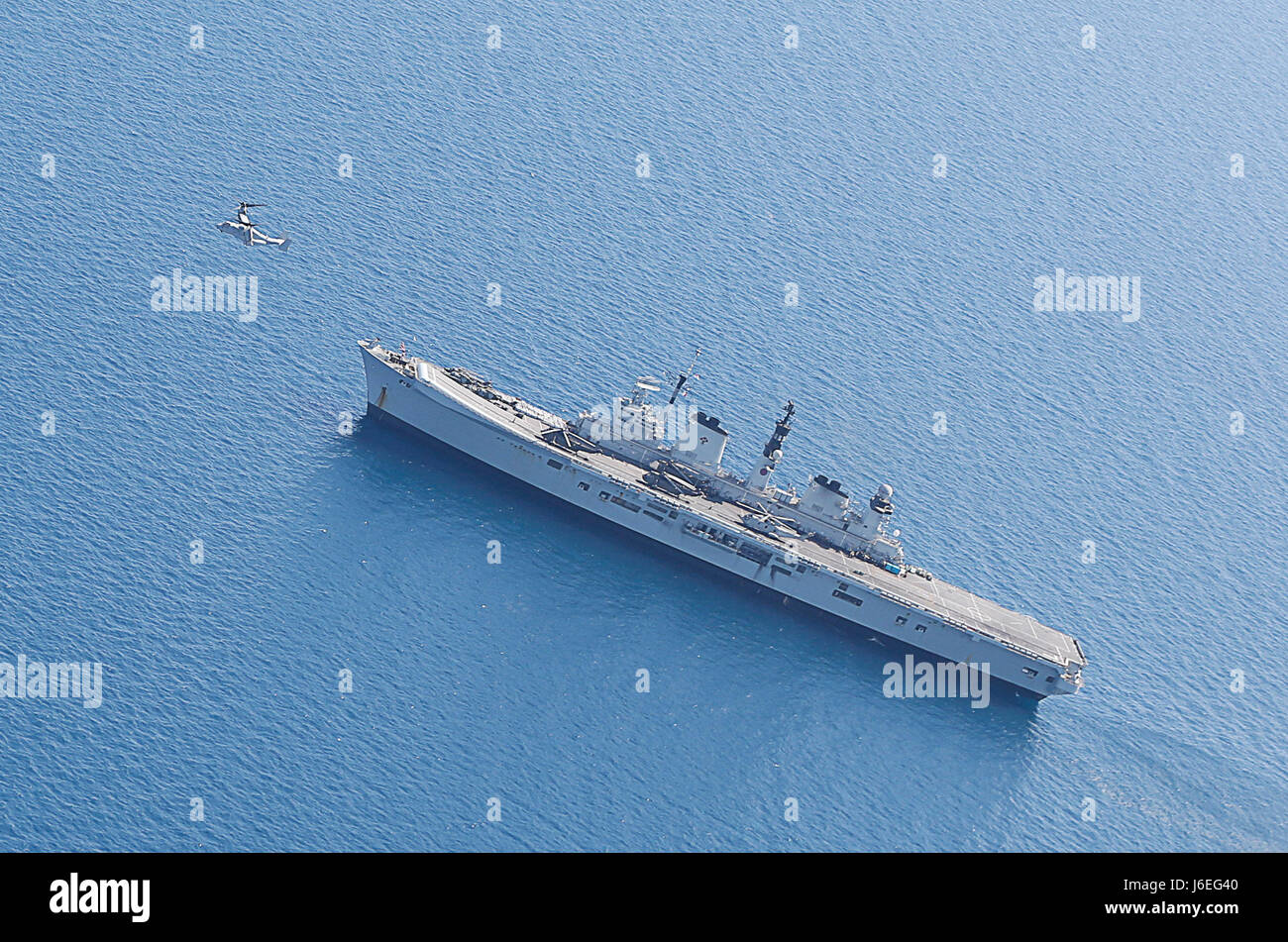 An MV-22B Osprey departs from the HMS Illustrious in the Philippine Sea ...