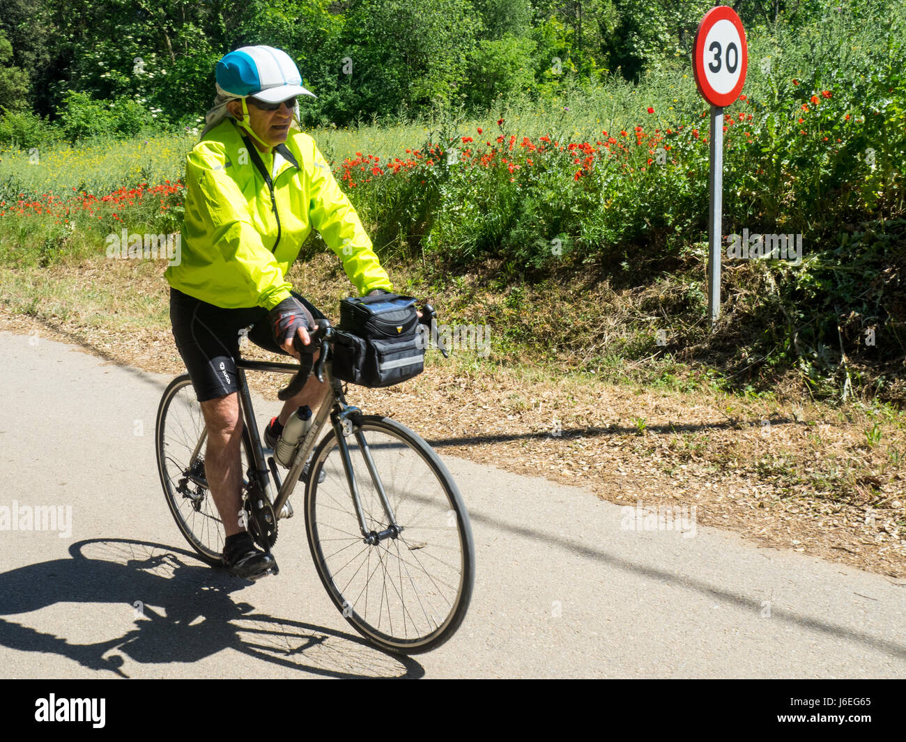 A male touring cyclist riding her titanium bicycle in the countryside ...