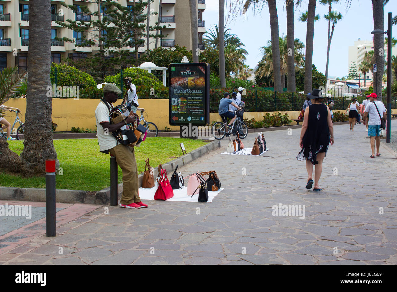 West African street traders selling sun glasses handbags and watches ...