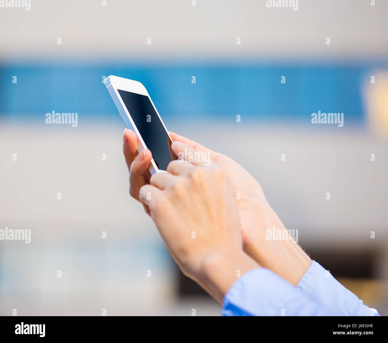 Closeup young female hands using, holding smart phone isolated on city ...