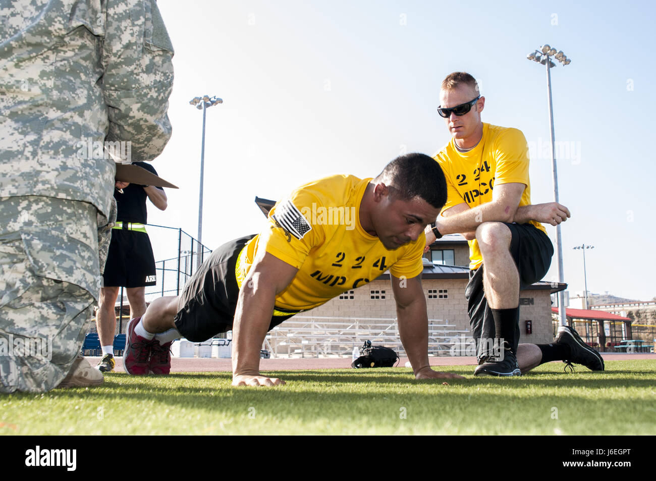 A corporal with the 525th MP Bn. performs pushups as members of his ...