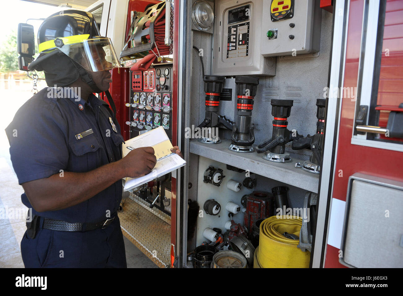 A fire station engineer conducts a truck inspection at the beginning of ...