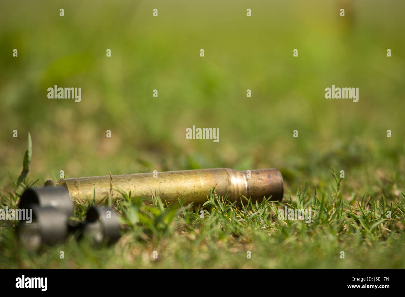 A casing from a .50 caliber round lays on the ground after being fired ...