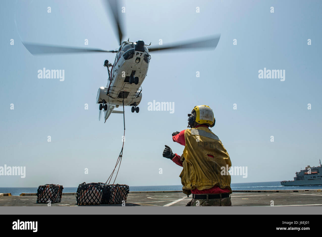 An Aviation Boatswain's Mate signals a SA-330 Puma helicopter during ...