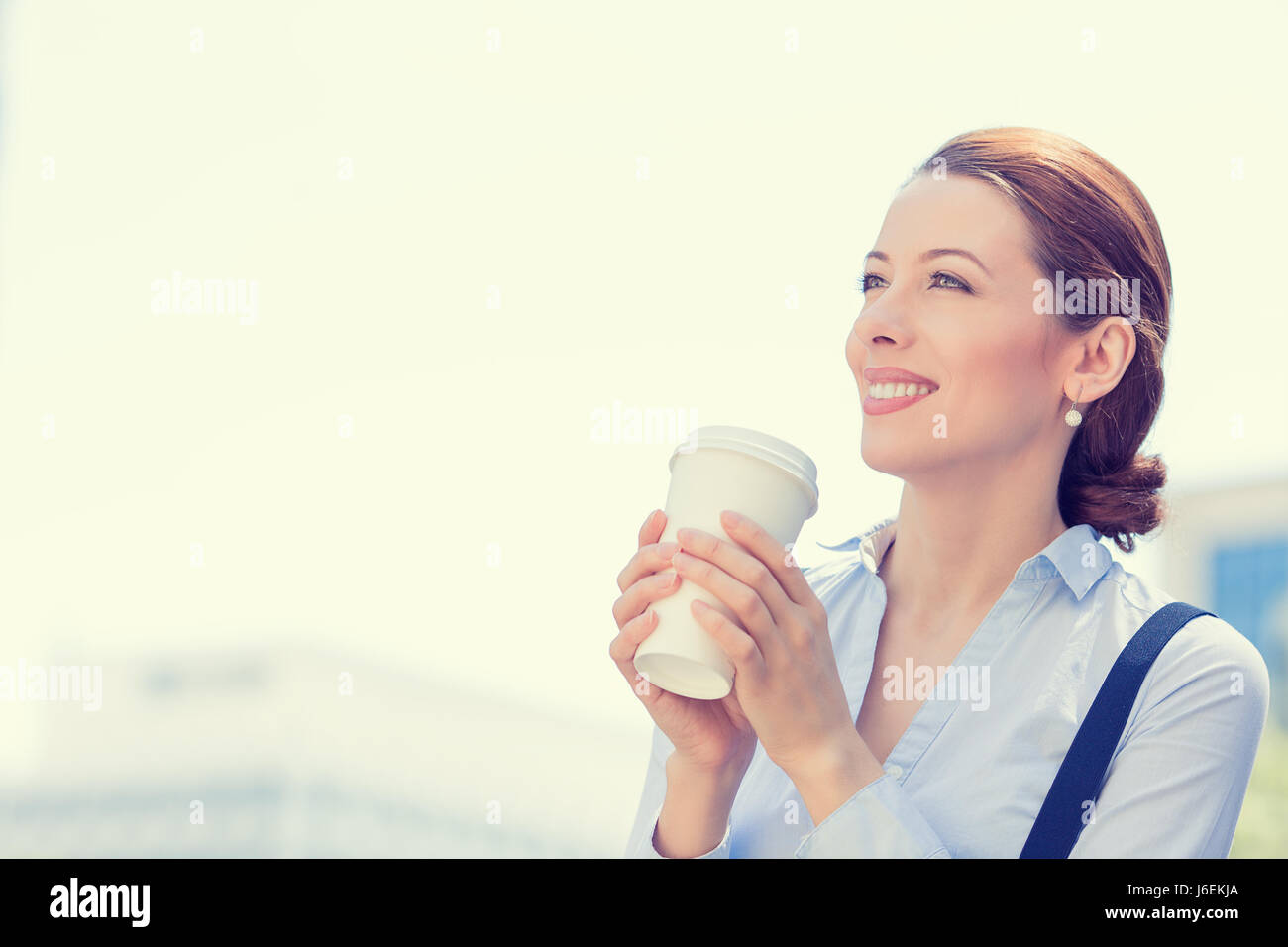 Portrait woman drinking coffee in sun standing outdoor in sunshine ...