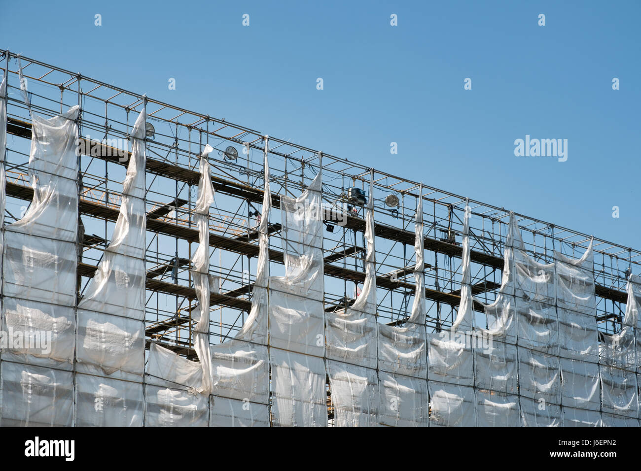 scaffolding with white canvas and blue sky background Stock Photo - Alamy