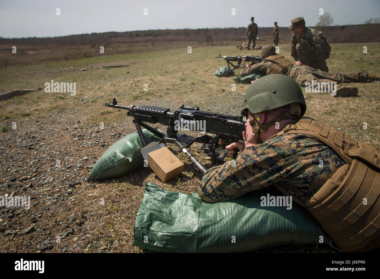 A U.S. Marine with Headquarters and Service Battalion fires the M240B ...