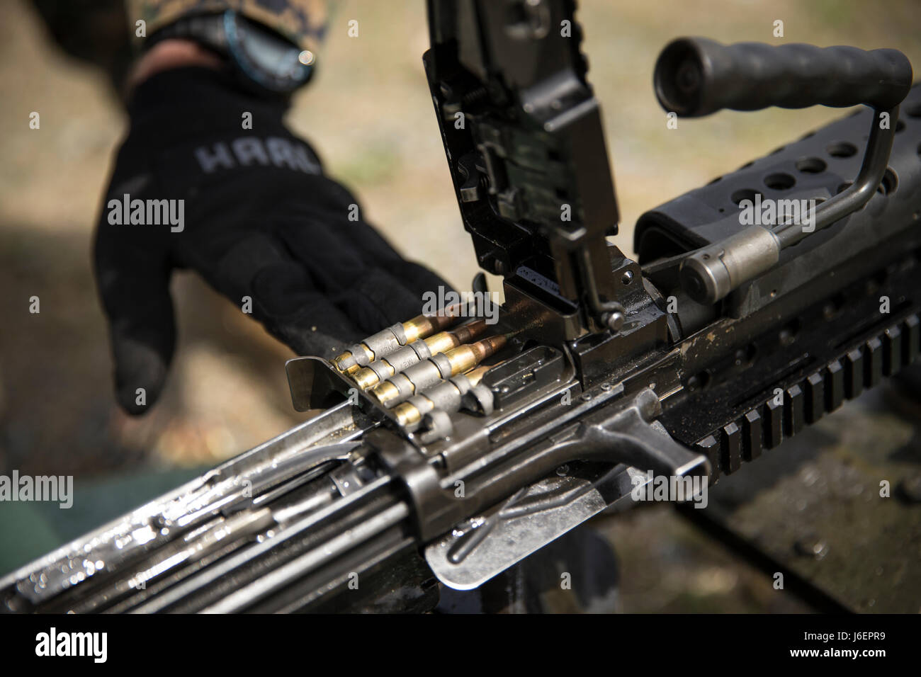 A U.S. Marine with Headquarters and Service Battalion reloads the M240B ...