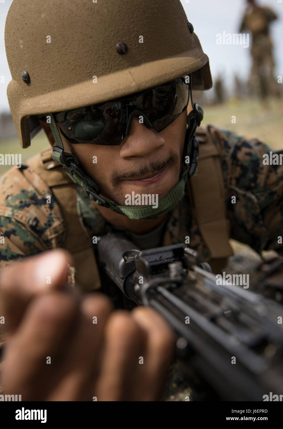 A U.S. Marine with Headquarters and Service Battalion fires the M240B ...