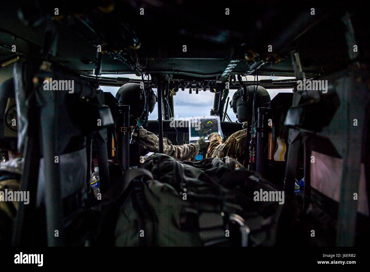 U.S. Army personnel coordinate on a map while a UH-60 Blackhawk ...