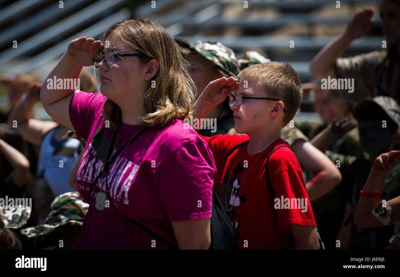 Military children render salutes through the playing of retreat during ...