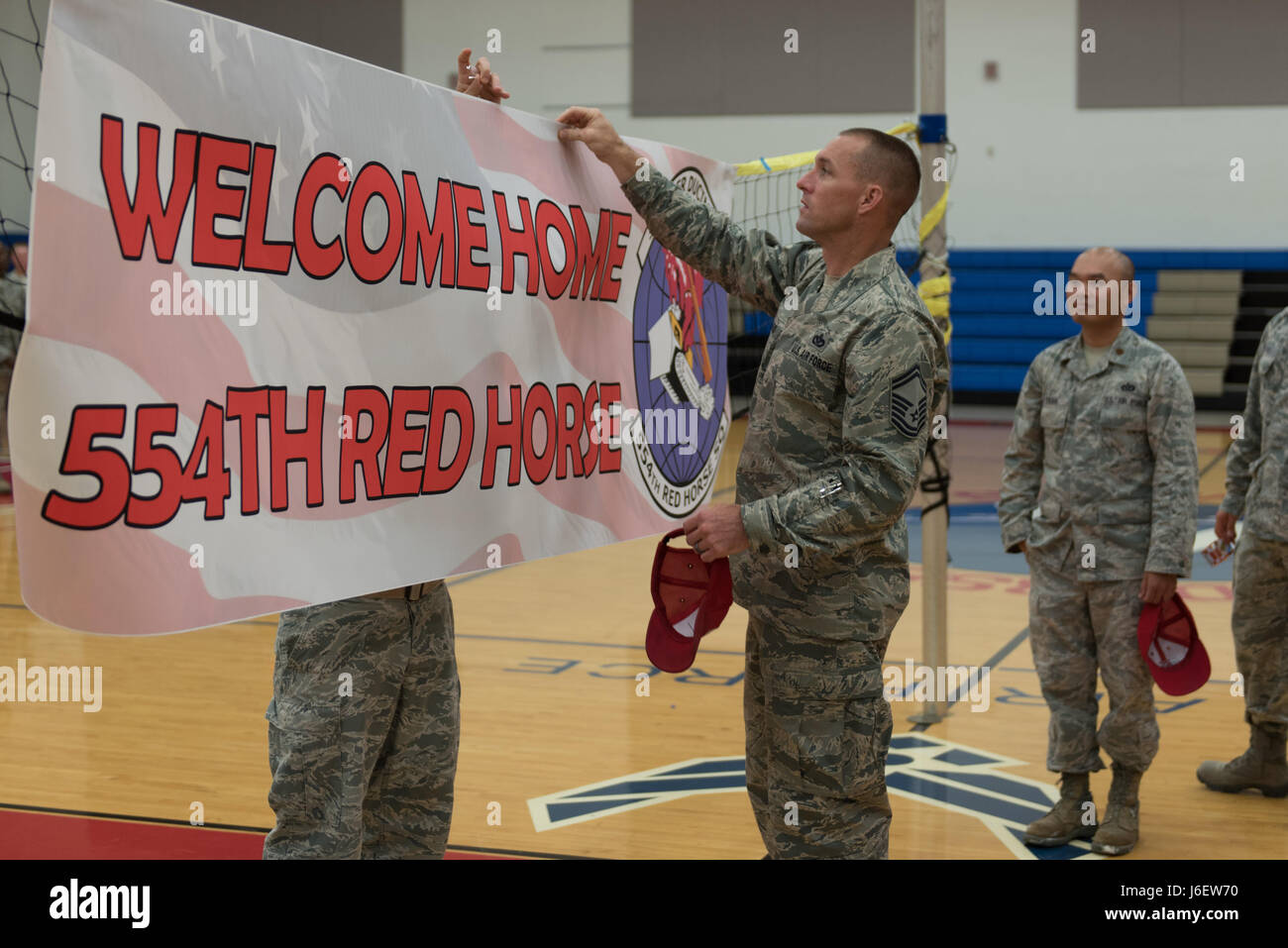 Airmen from the 554th RED HORSE Squadron hang a sign to welcome back ...