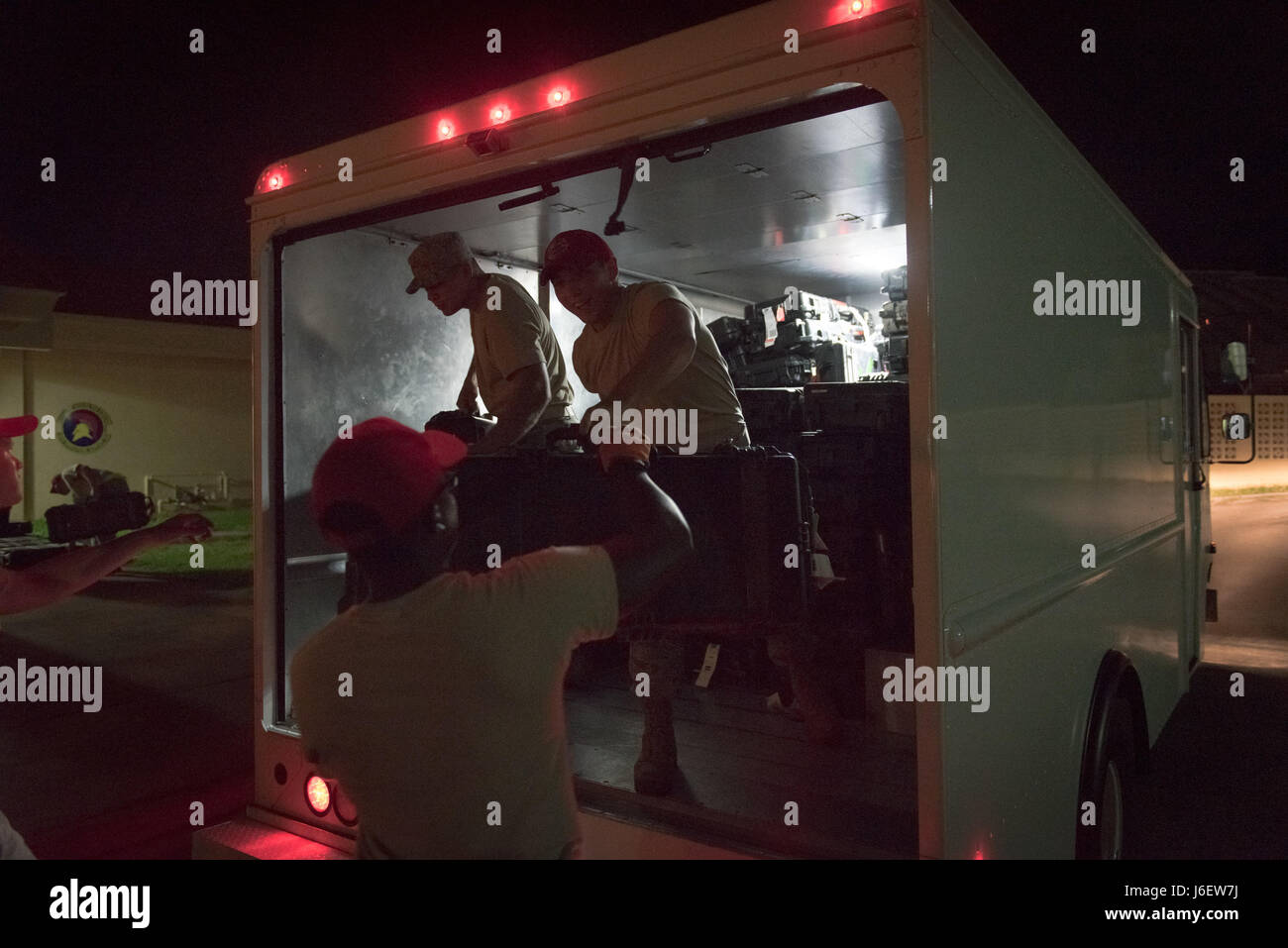 Airmen from the 554th RED HORSE Squadron unload cased weapons that were ...