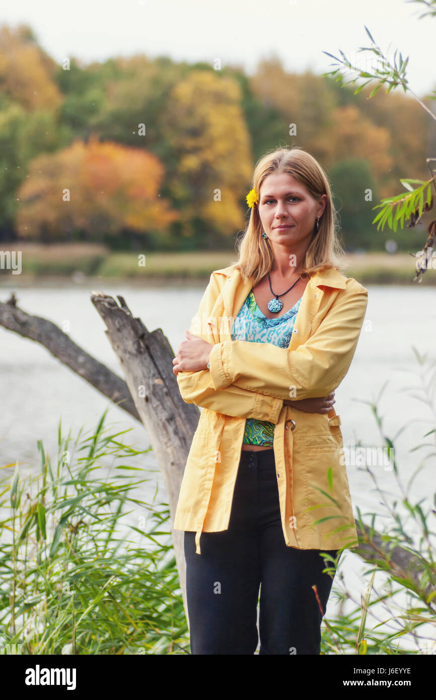 Beautiful young woman wearing yellow jacket outdoors Stock Photo - Alamy