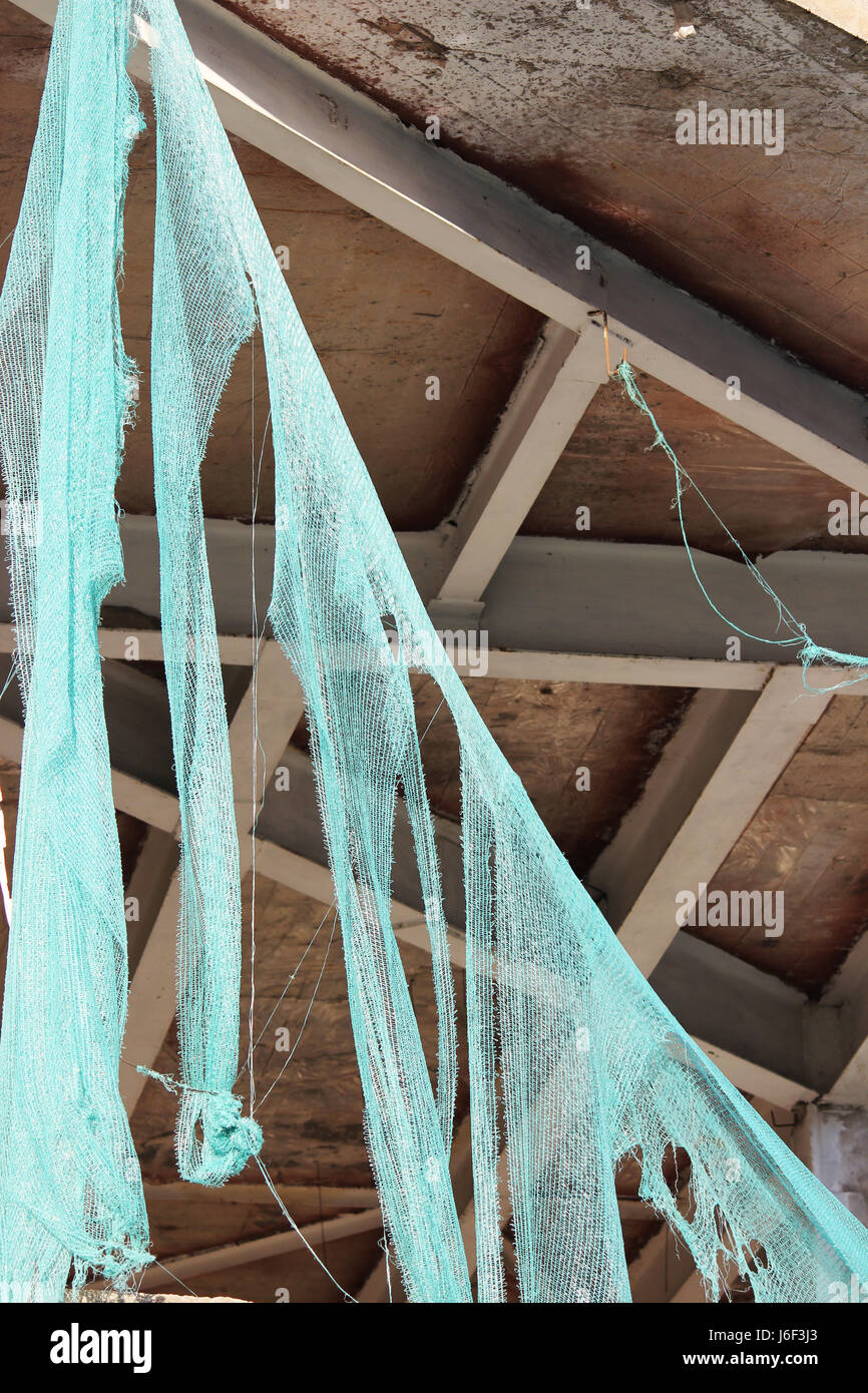 Torn green building mesh on an unguarded unfinished abandoned building ...