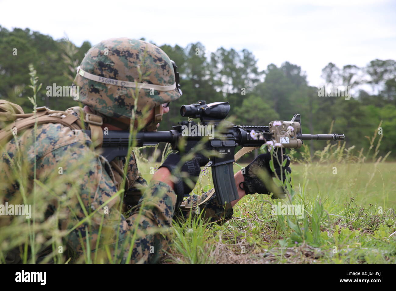 A Marine sights in on a simulated target during a fire team training ...