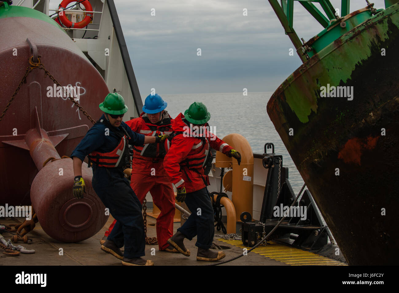 Coast Guard Cutter Oak crewmembers move away from a buoy after ...