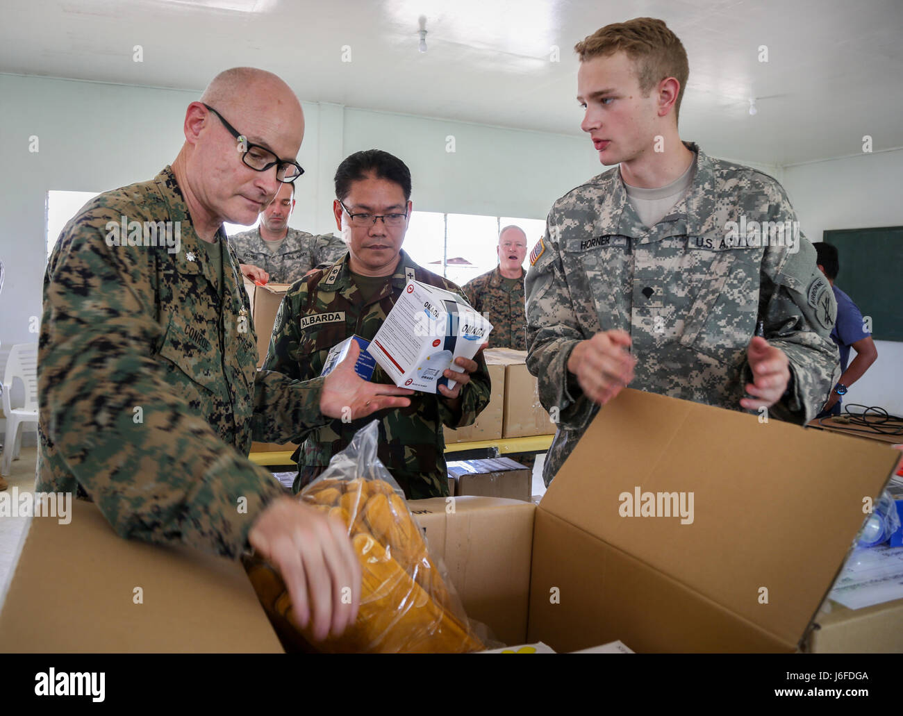 U.S. Navy Cmdr. Jon Conroe presents disaster relief supplies to ...