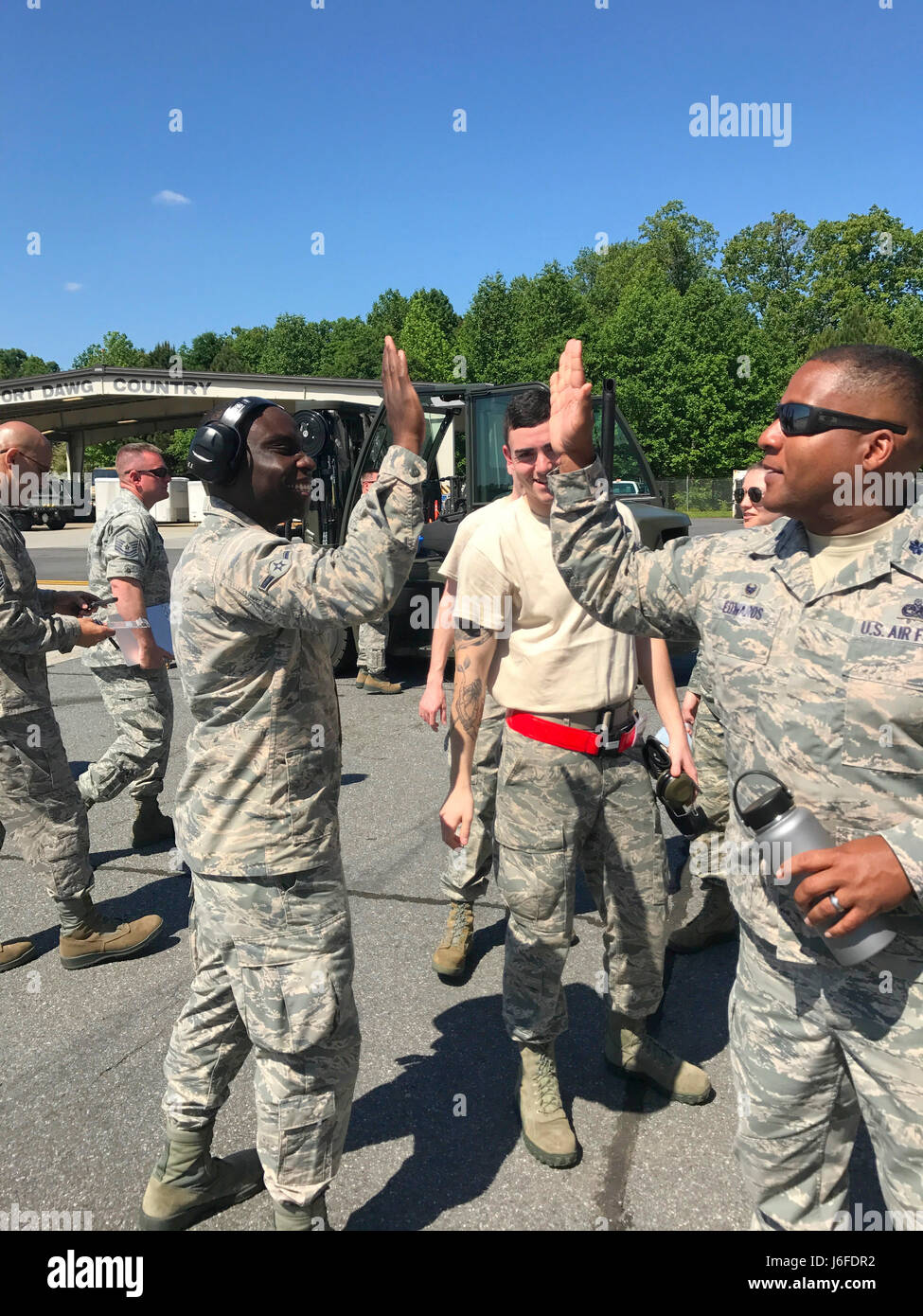 Airman Keith Omweri (front left) exchanges high-fives with Lt. Col ...