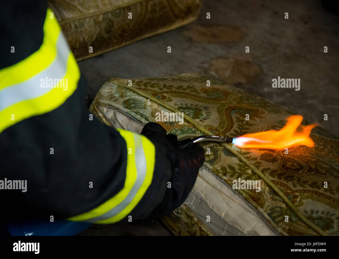Instructor, Jason Krusen, sets fire to a couch cushion to demonstrate ...