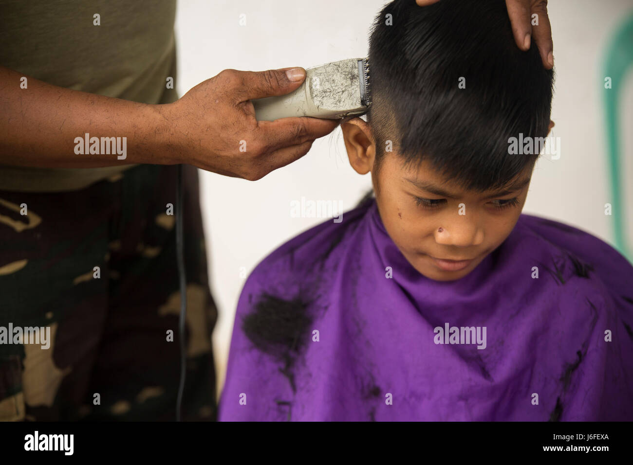 Philippine Army Pfc. Nolen Selose, 3rd Infantry Division barber, cuts a ...