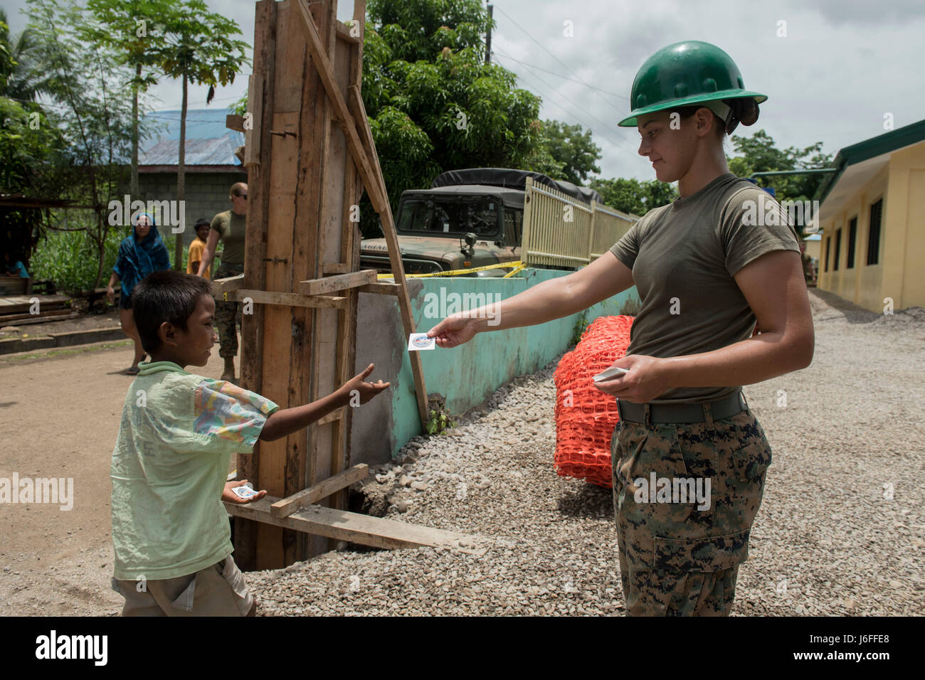 U.S. Marine Lance Cpl. Brook Klahn, right, gives a Balikatan sticker to ...