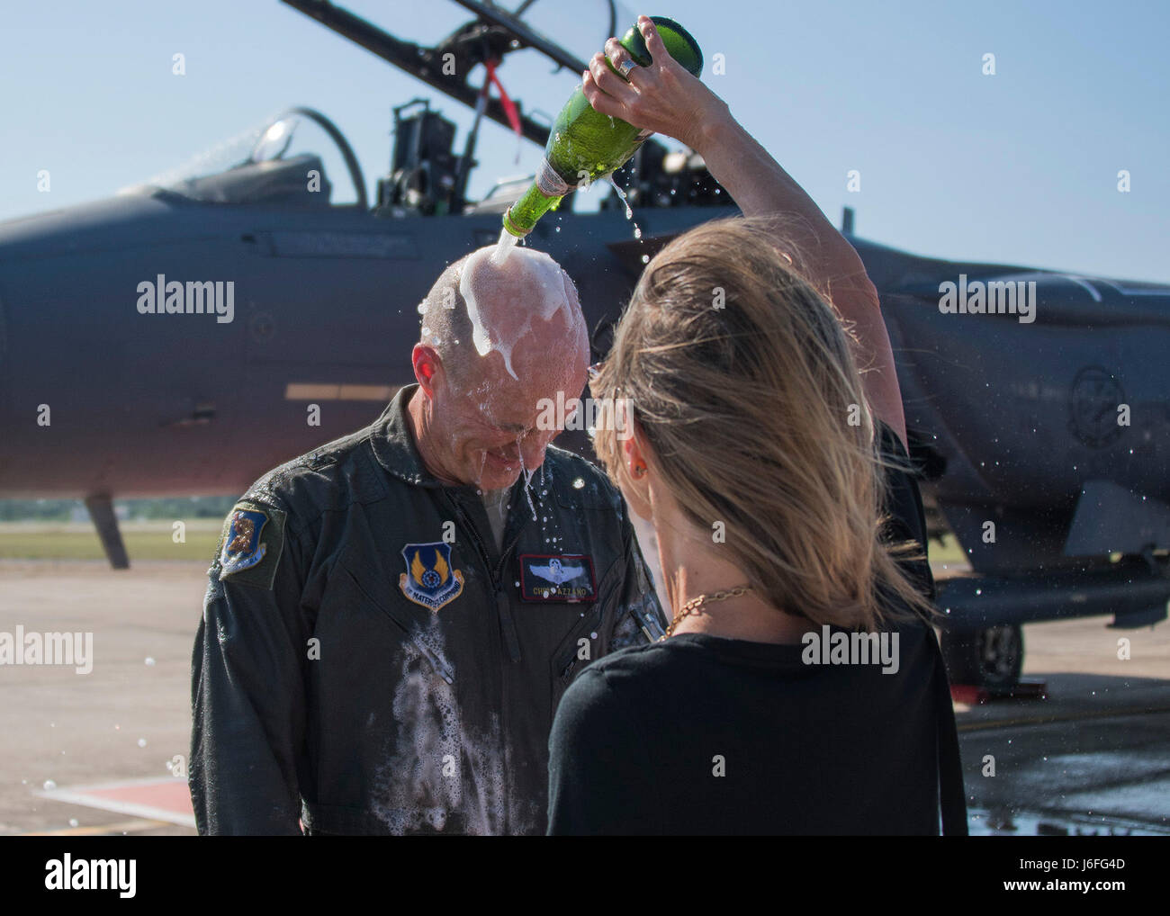 Jennifer Azzano, pours a celebratory bottle of champagne on her husband ...