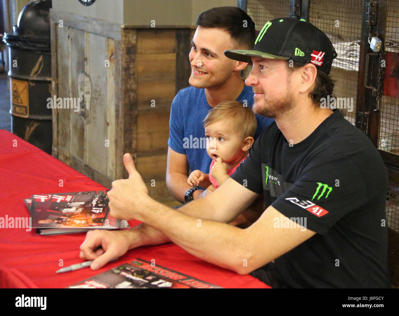 NASCAR driver Kurt Busch poses with Cpl. Cody Mooney and his son for a ...