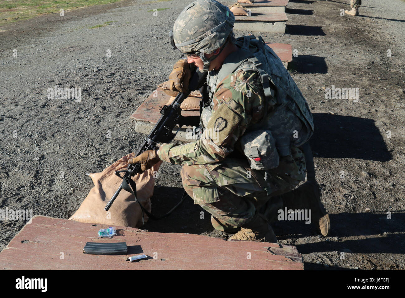 A Stryker gunner lubricates and checks his rifle during a qualification ...
