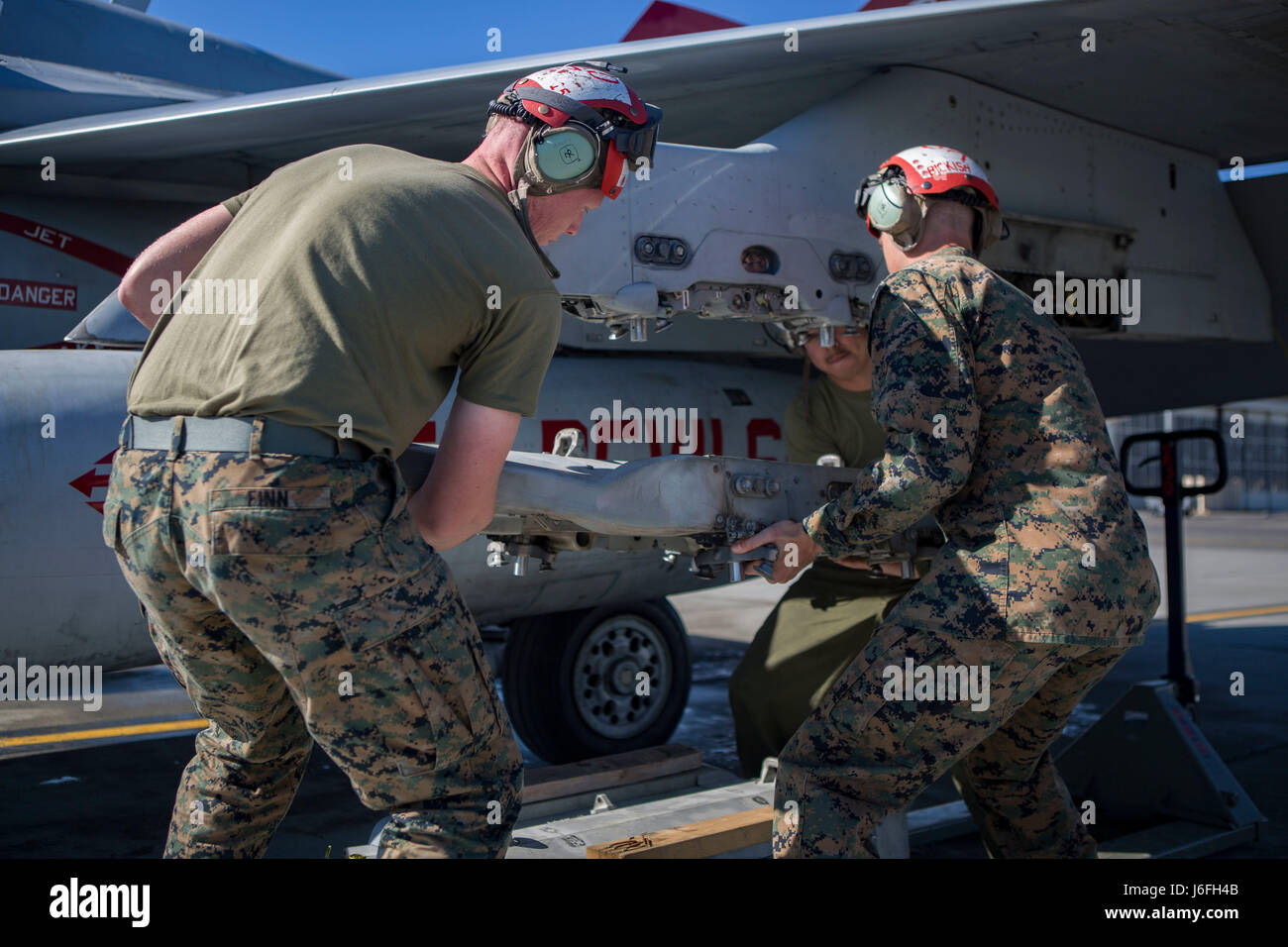 U.S. Marines with Marine Fighter Attack Squadron (VMFA) 232, load an F ...