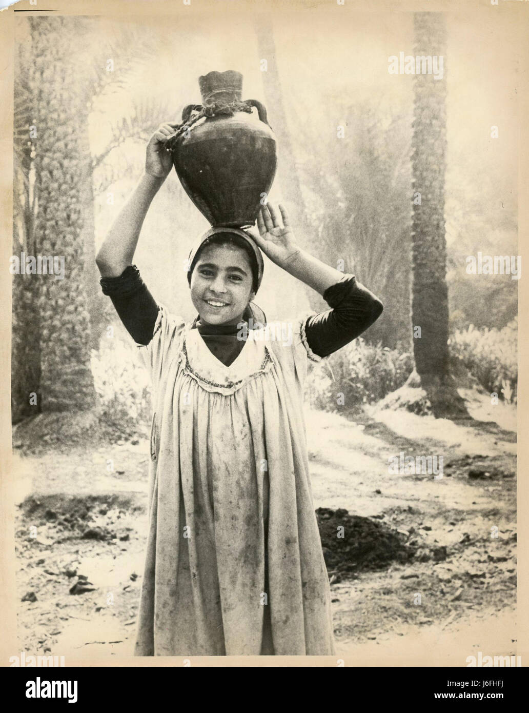 A LITTLE GIRL SMILING WITH A POT ON HER HEAD Stock Photo - Alamy