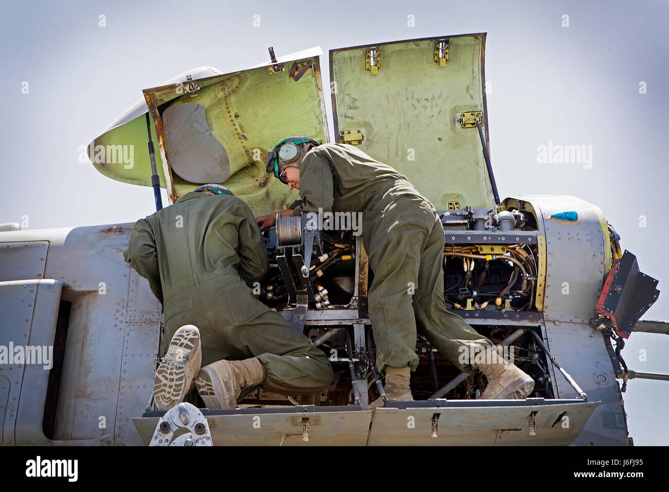 Marines with Marine Medium Tiltrotor Squadron (VMM) 363 conduct maintenance on an MV-22 Osprey ...