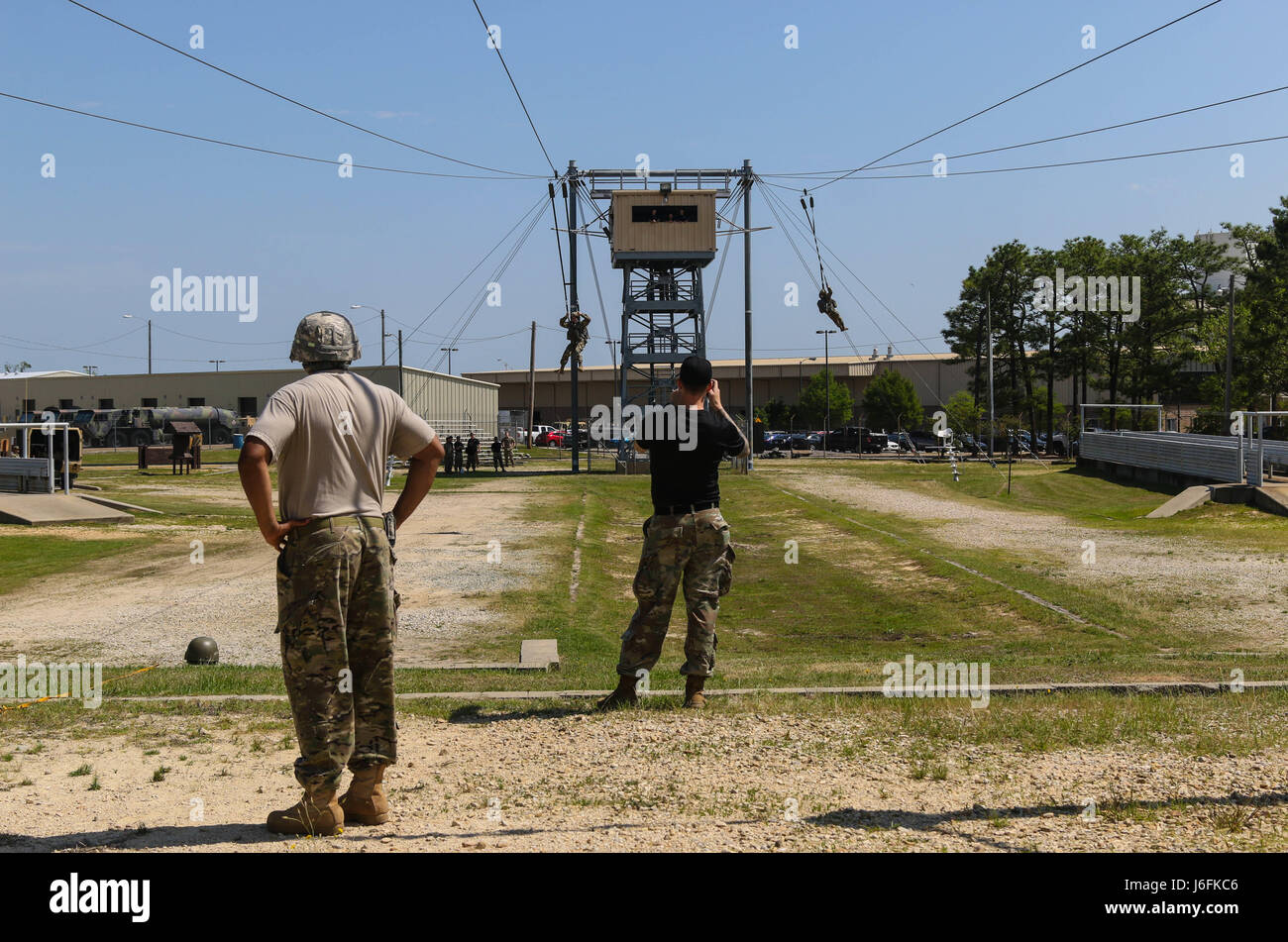 A Jump Master looks on as paratroopers jump from the jump tower ...