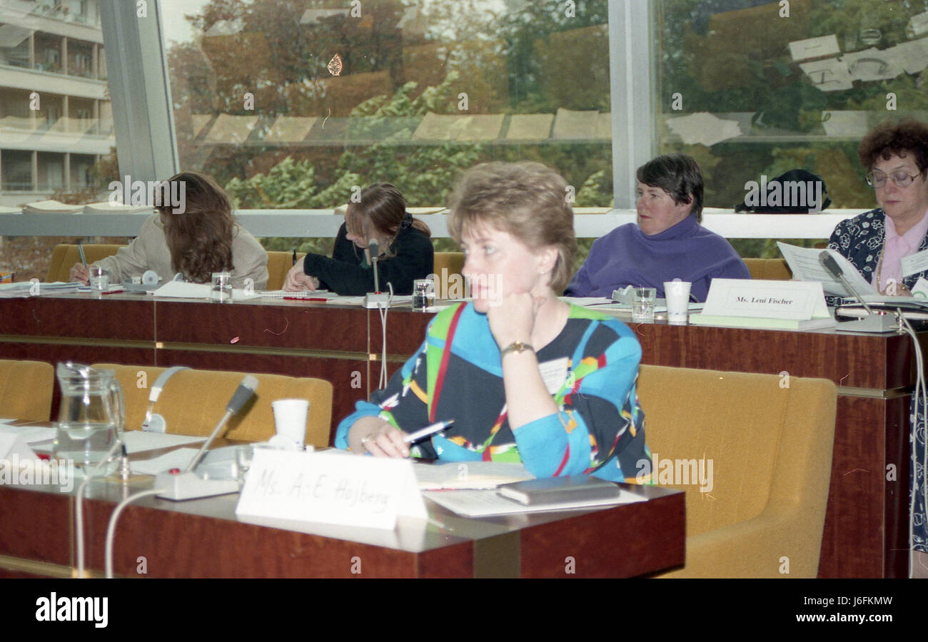 Two women participate in a military planning meeting, taking notes and ...