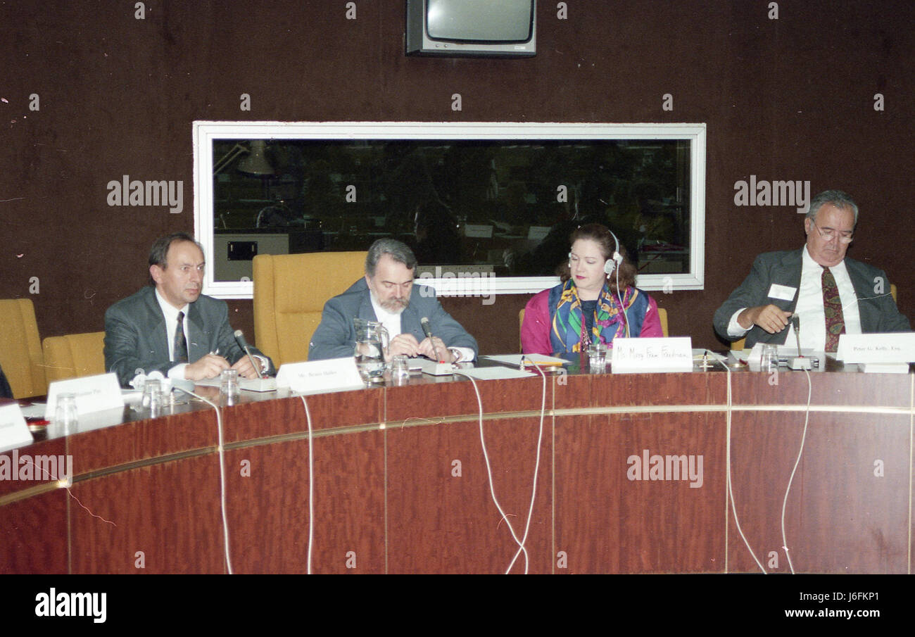 THREE MEN AND A WOMEN ON THE PANEL GOING OVER NOTES AND LISTENING ON ...