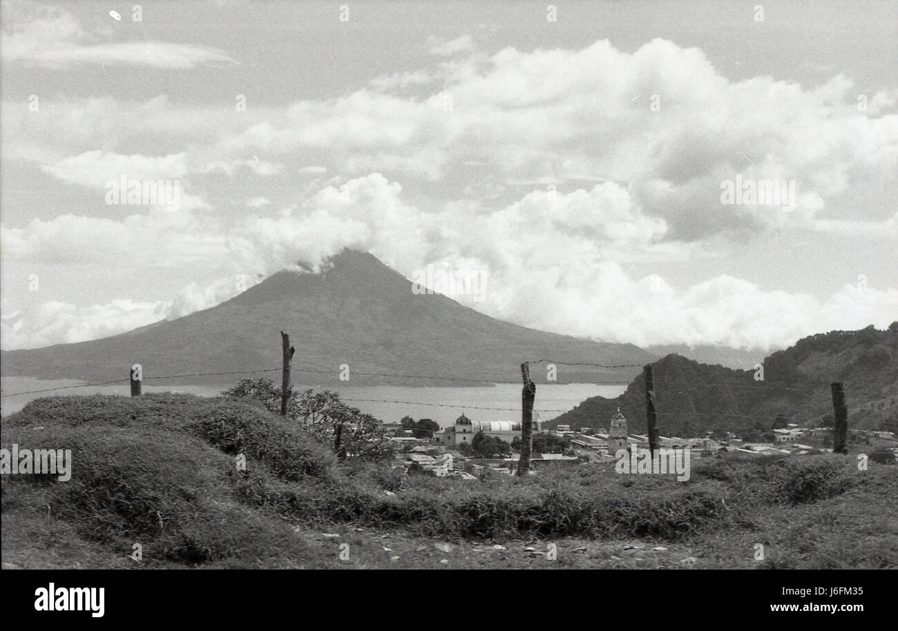 A village is situated at the base of a mountain, showing terrain ...