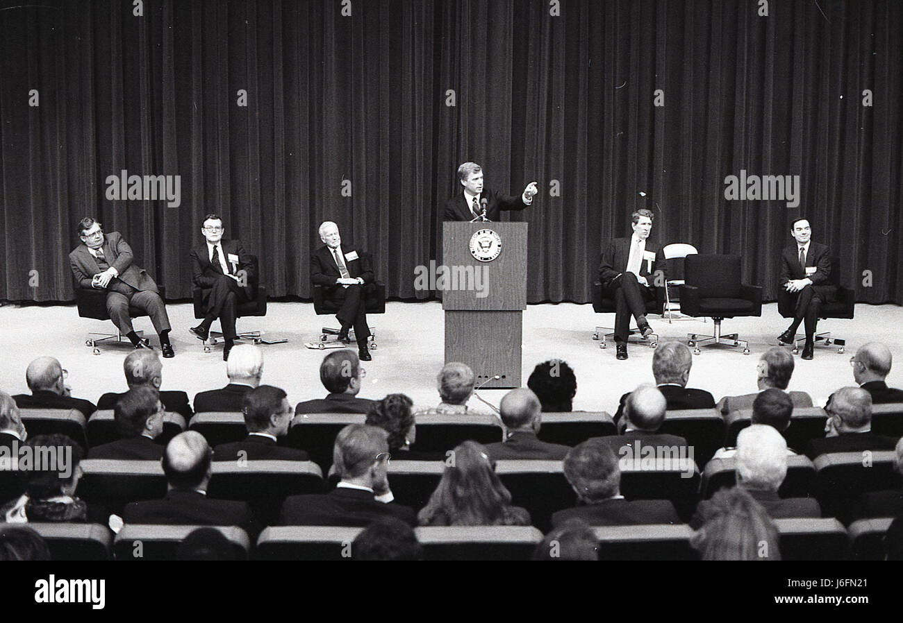 THERE ARE A GROUP OF MEN ON STAGE WITH ONE MAN AT THE PODIUM GIVING A ...