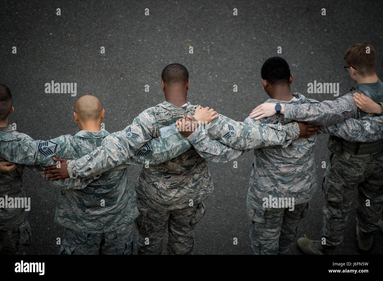 Participants in a Memorial 5K Ruck March join arms during a group ...